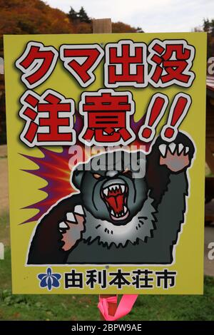 Japanese warning sign about wild bears. Yellow and black sign, black ...