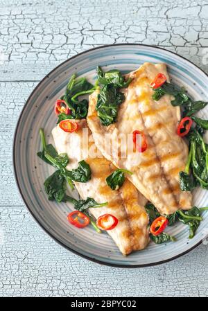Grilled sea bream fish fillet with spinach and chili pepper Stock Photo ...