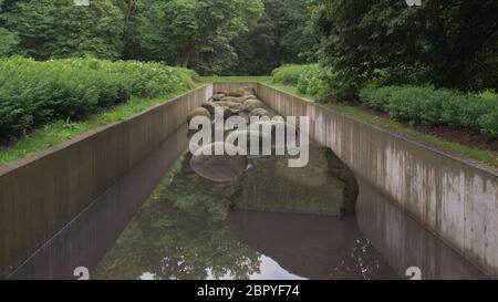 Pond channel with stones in park background Stock Photo - Alamy