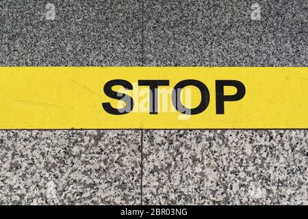Stop sign yellow line at marble floor warning Stock Photo - Alamy