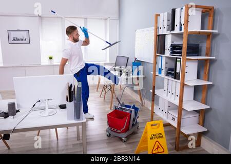 Man Janitor Slipping While Mopping Floor In Modern Office Stock Photo ...