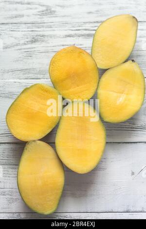 Halves of mango on the wooden background Stock Photo - Alamy