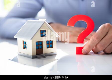 Man Holding Question Mark Next To House Model Stock Photo - Alamy