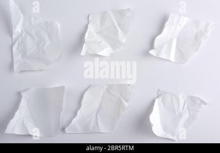 crumpled empty torn pieces of white paper on a blue background, top ...