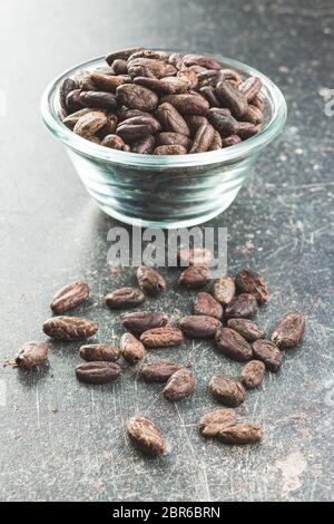 Dark cocoa beans in bowl Stock Photo - Alamy