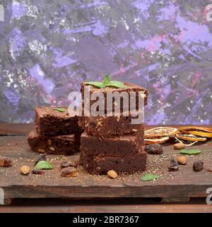 stack of baked square pieces of chocolate brownie cake on brown wooden ...