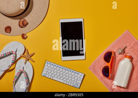 Tablet computer with flip flops, sunscreen and beach decor on white ...