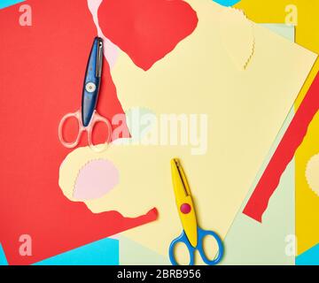 Child cutting colored paper with scissors at the table Stock Photo - Alamy