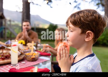 Caucasian family saying grace together before eating Stock Photo - Alamy