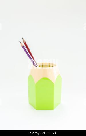 A metal grid container with pencils on a wooden table Stock Photo - Alamy