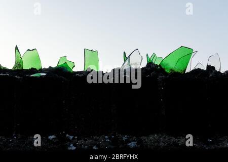 Glass shards on top of a wall for protection, Spain Stock Photo - Alamy