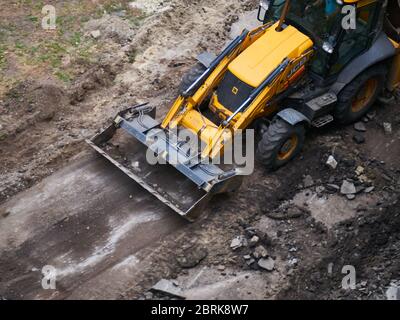 Hydraulic Excavator Removing Remains of asphalt. Road reconstruction ...