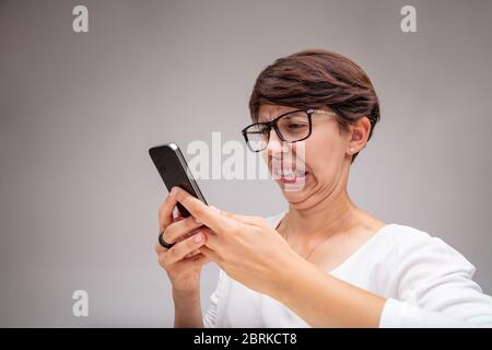 Woman reacting in revulsion to her mobile phone Stock Photo - Alamy