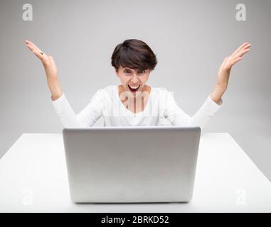 Incredulous business woman gawping at a laptop Stock Photo - Alamy