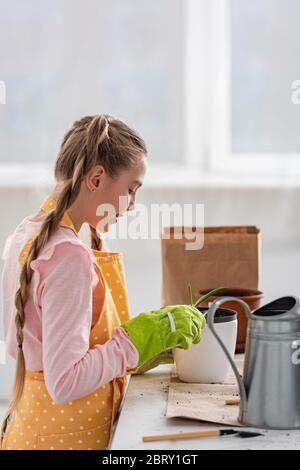Side view of focused girl in funny sweater hanging red bauble on ...