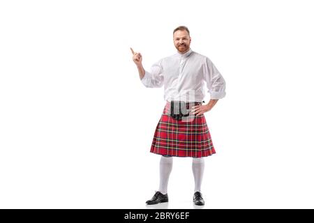 smiling Scottish redhead bearded man in red tartan kilt on white ...
