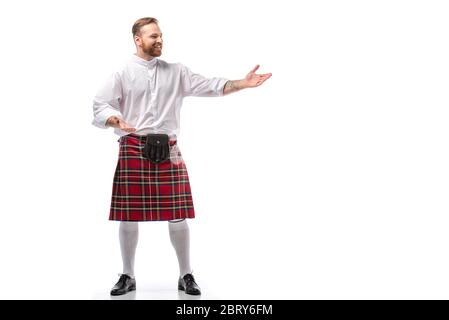 smiling Scottish redhead man in red kilt with crossed arms on white ...