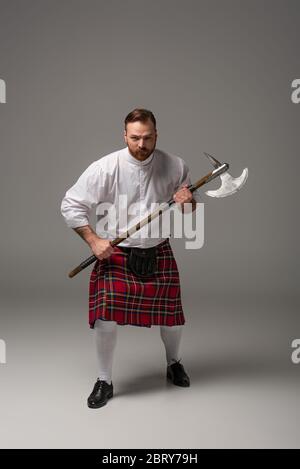 Ancient Scottish warrior in kilt with winged helmet, weapons and shield ...