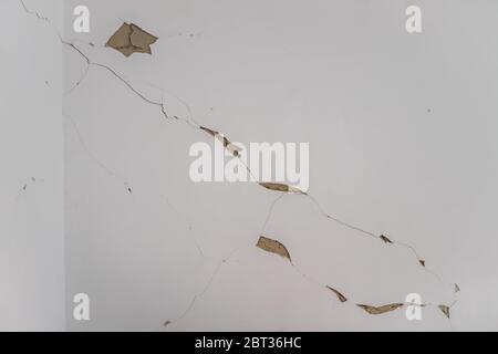House interior damage on wall with glass strip glued across crack by ...