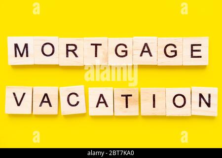 Wooden blocks with the word Mortgage and house in the hands of a ...