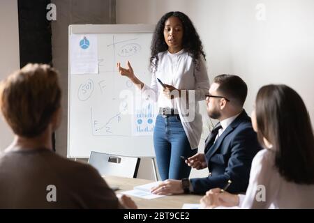 African American man giving presentation to colleagues at international ...