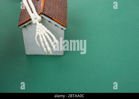 Small model house and human skeleton hand as horror concept Stock Photo ...