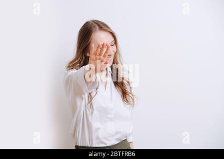 Attractive young woman blocking with hand and gesturing NO with finger ...