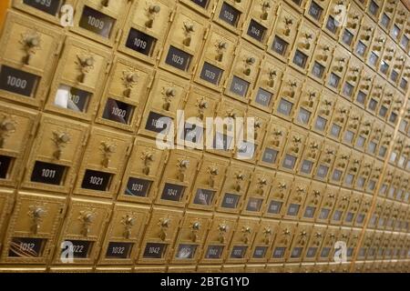 Row of vintage brass pigeonhole mailboxes with doors and combination ...