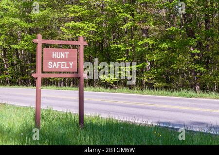 A wooden sign saying HUNT SAFELY on the side of a road in Warren county ...