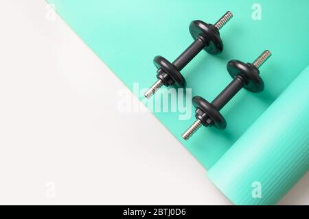 Sport black dumbbells and turquoise yoga mat Stock Photo - Alamy