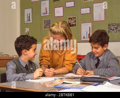 Teacher checking pupils work Stock Photo - Alamy