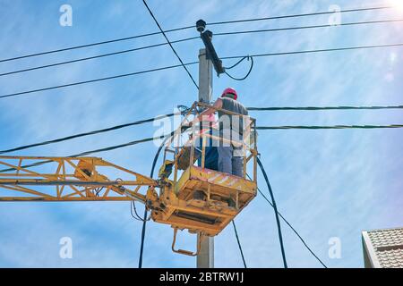 electrician in a car tower to repair power lines Stock Photo - Alamy