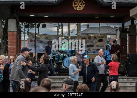Rcok band in concert, with people dancing in forefground. Singer, bass ...