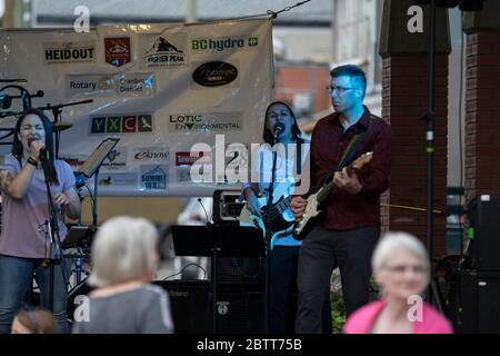 Rcok band in concert, with people dancing in forefground. Singer, bass ...