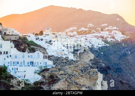 Traditional white cave houses on a cliff on the island Santorini ...