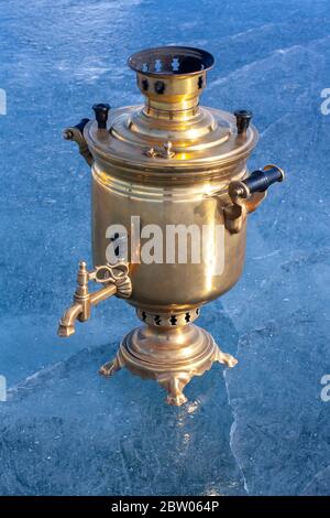 Retro samovar stands in the lake. A copper Russian wood-fired kettle ...