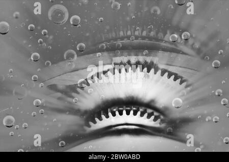 Metal gears in liquid or oil with bubbles. Black-and-white. Oil change ...
