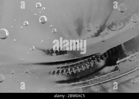 Metal gears in liquid or oil with bubbles. Black and white Stock Photo ...