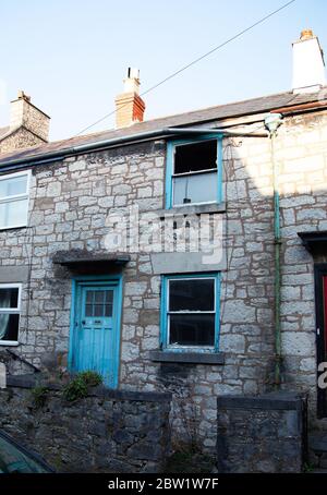 Unkempt / untidy exterior of an empty / disused stone-built terraced ...