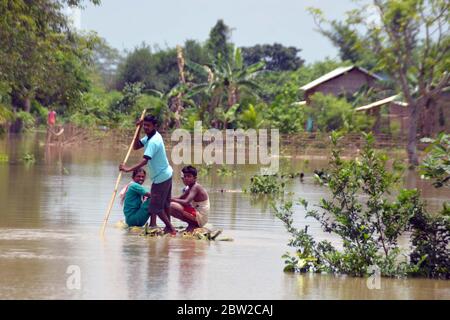 A flood affected family moves on a boat past partially submerged houses ...