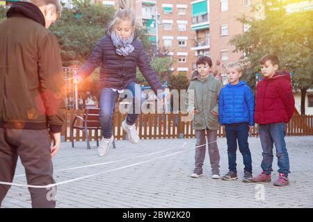 children playing elastic playground game, 70s Stock Photo - Alamy