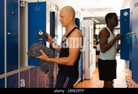 Two athletes in the locker room after training Stock Photo - Alamy