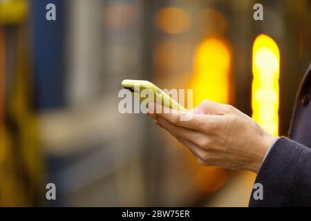 Closeup of a blurred male hand using a phone Stock Photo - Alamy