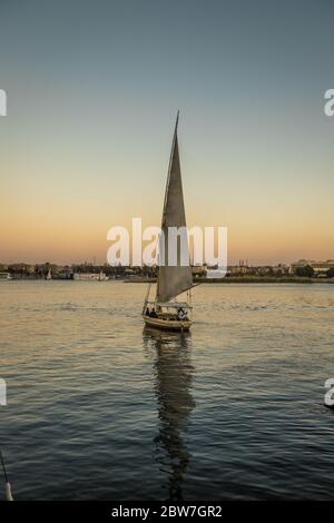 Traditional Feluccas sailing the Nile, during golden hour in Aswan ...