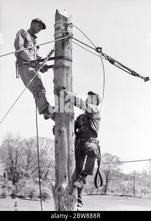 1930s TWO MEN ELECTRIC LINEMEN INSTALLING POWER LINES ON A WOODEN ...