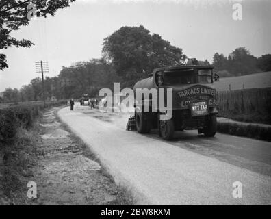 Workers are using a tar spraying machine from Taroads Limited to ...