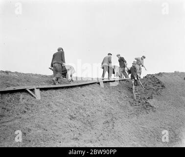 Workers increasing the river defences and doing repairs on the river ...