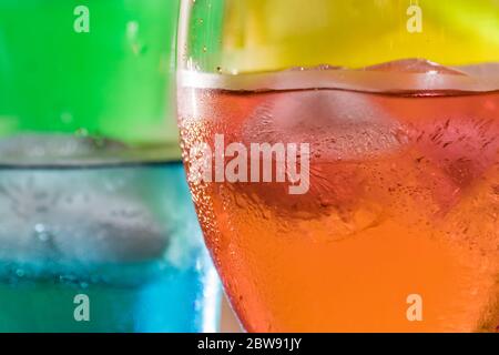 multi colored liquid in pretty glasses with iceon table Stock Photo - Alamy