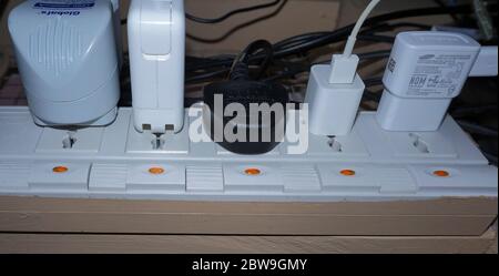 Multiple electrical plugs in overloaded wall outlet Stock Photo - Alamy