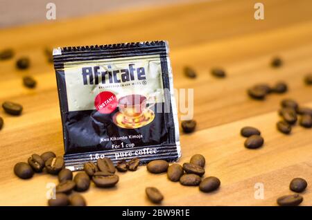 A sachet of instant coffee from Africafe with coffee beans around in a ...